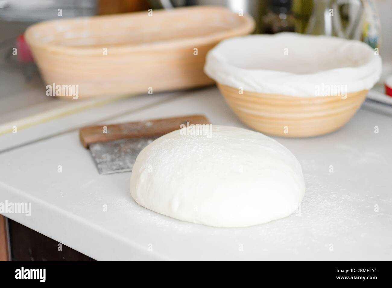 Homemade freshly cooked dough on a white kitchen table with wicker ...