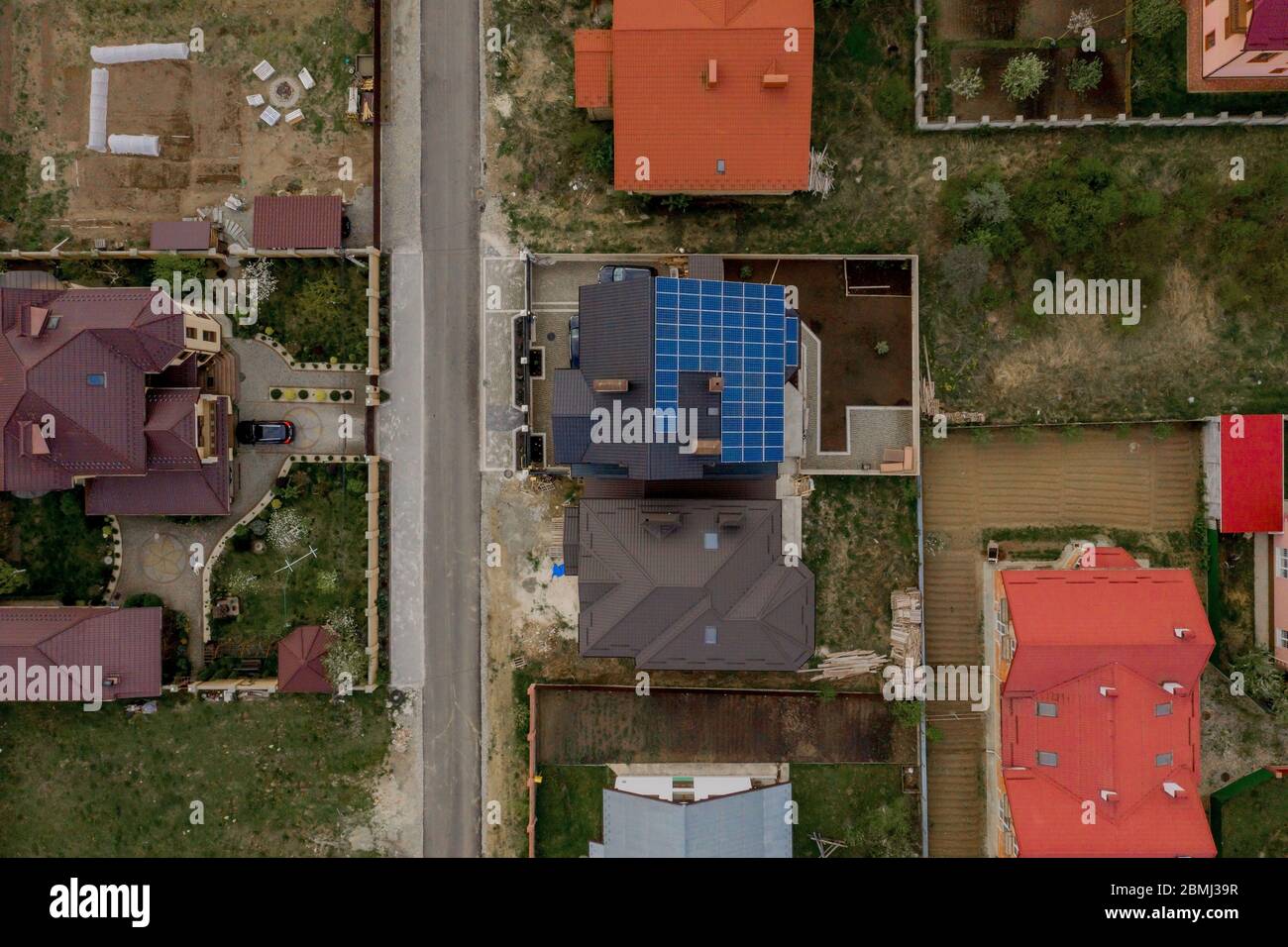 Aerial top view of a house with paved yard with green grass lawn with ...