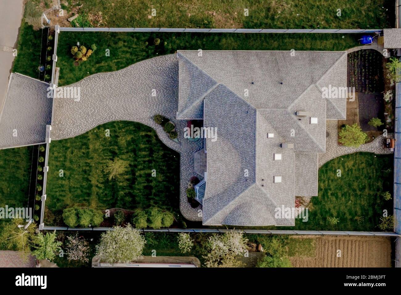 Aerial top view of a private house with paved yard with green grass ...