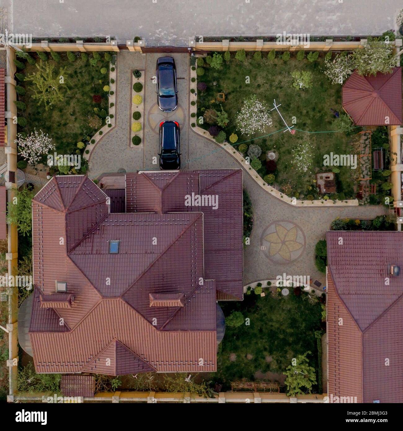 Aerial top view of a private house with paved yard with green grass ...