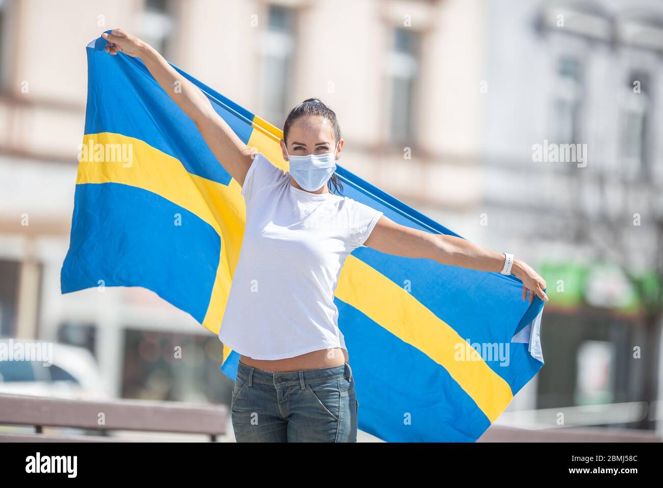 Beautiful smiling Swedish girl holds a flag while wearing a protective ...