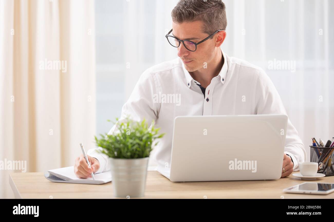 Man sitting desk writes notebook hi-res stock photography and images ...