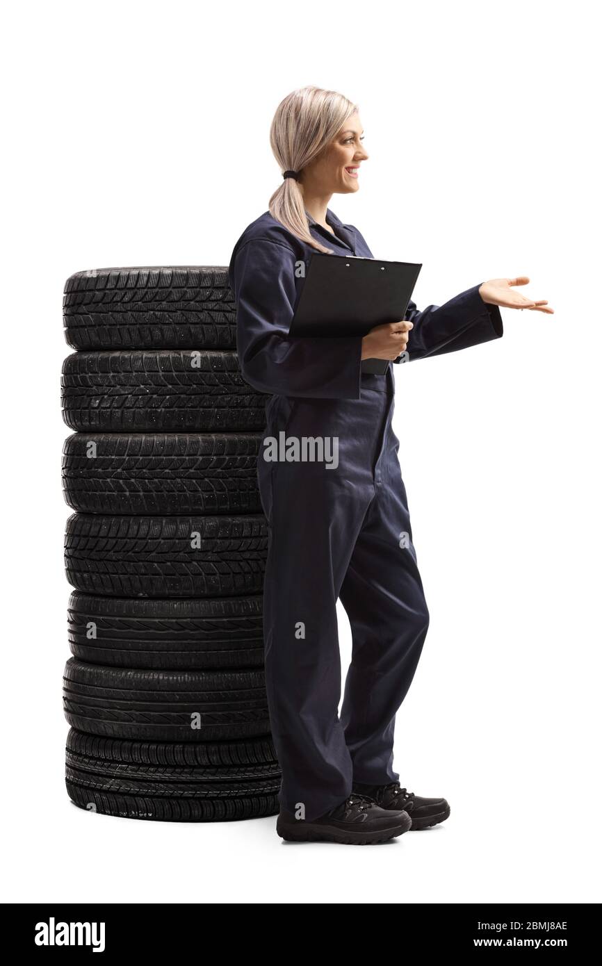 Full length profile shot of a female auto mechanic standing next to a ...