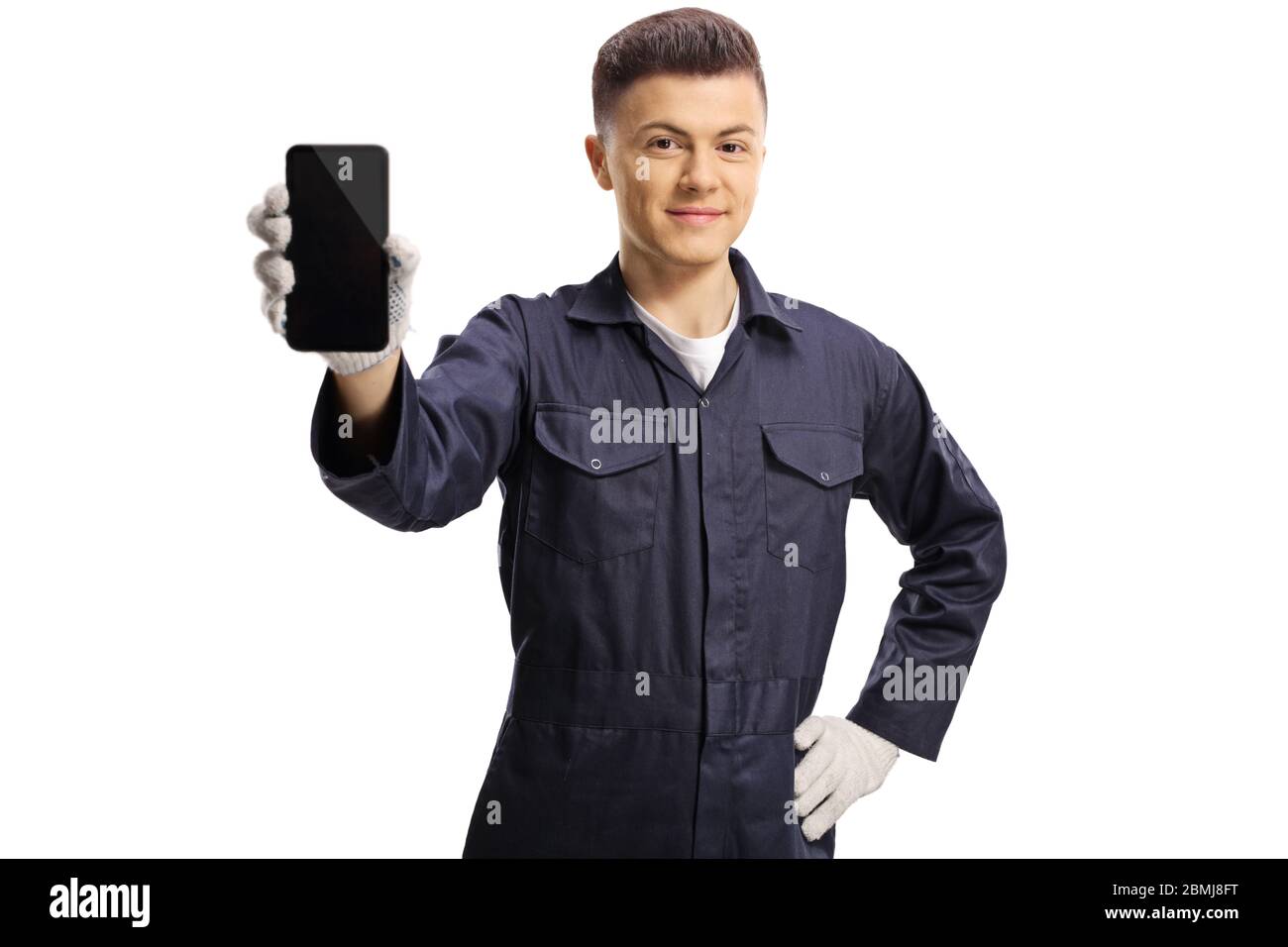Young mechanic holding a mobile phone isolated on white background ...