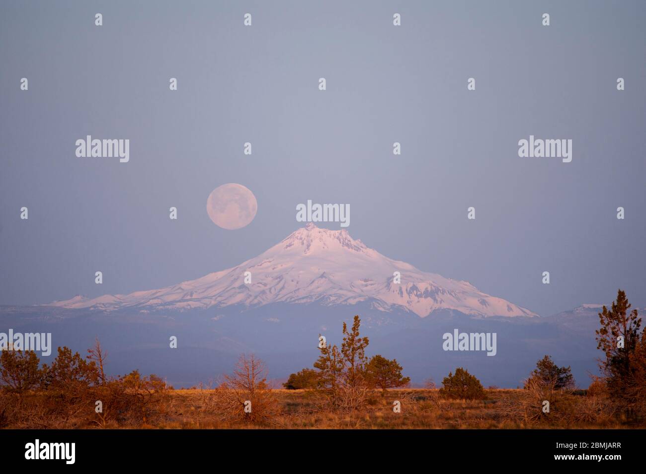 The full moon sets behind Oregon's Mt. Jefferson at dawn Stock Photo ...