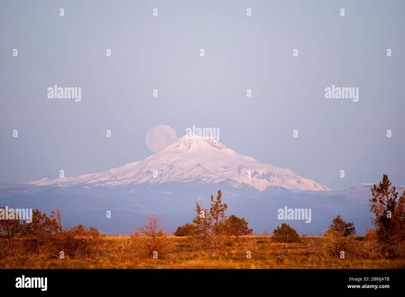 The full moon sets behind Oregon's Mt. Jefferson at dawn Stock Photo ...