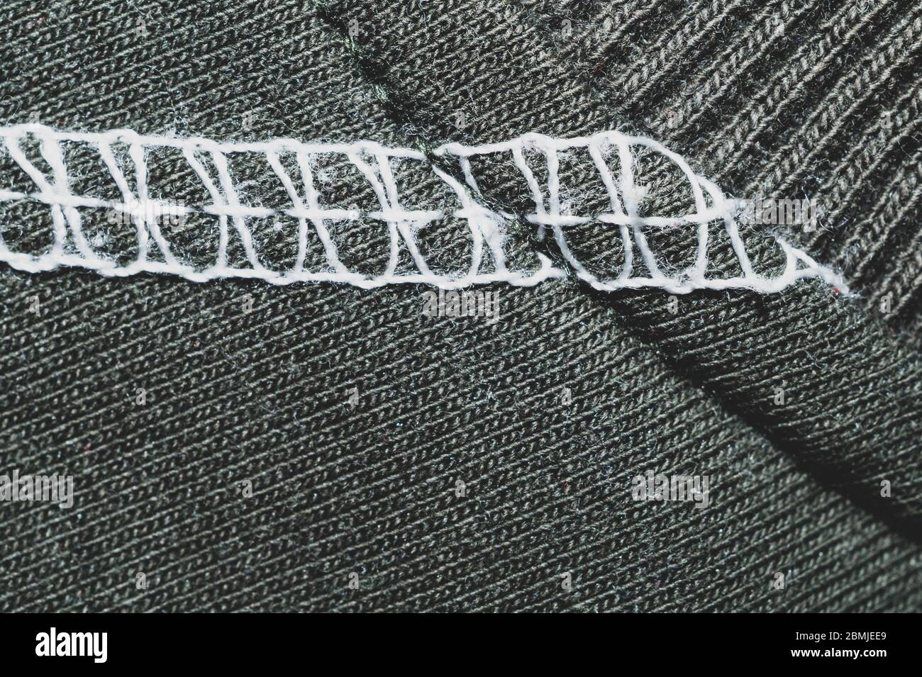 White seams on black fabric. stitches on textile material close up ...
