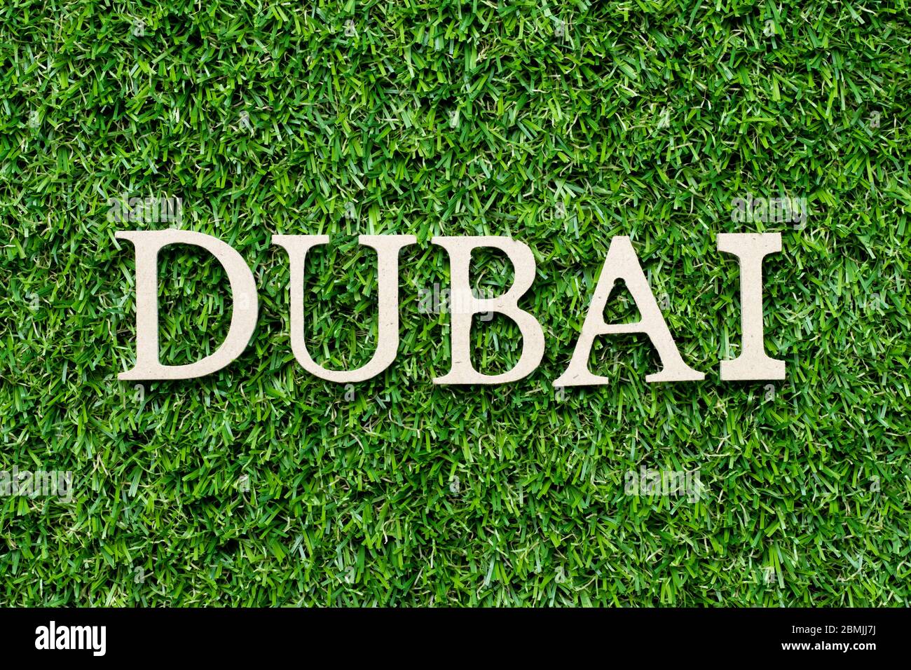 Wood alphabet letter in word Dubai on green grass background Stock ...