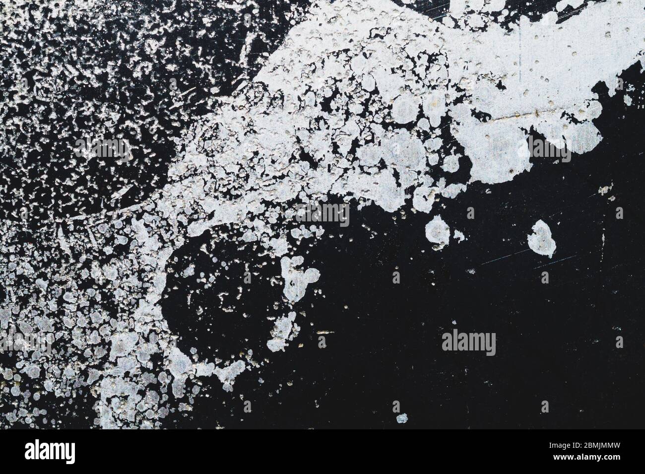 Black steel plate with white paint spots. metal surface with paint ...