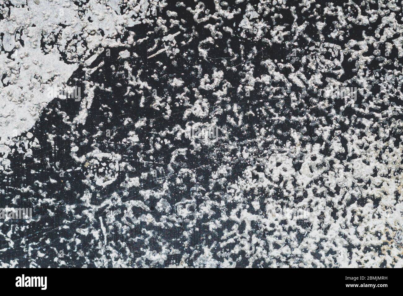 Black steel plate with white paint spots. metal surface with paint ...
