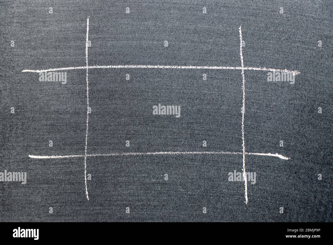 White color chalk hand drawing in square shape on black board ...