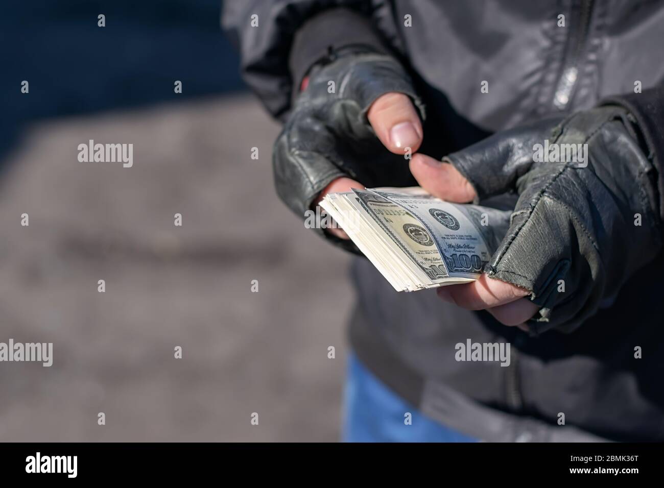 money in the hands of a bandit, a robber who counts the loot Stock ...