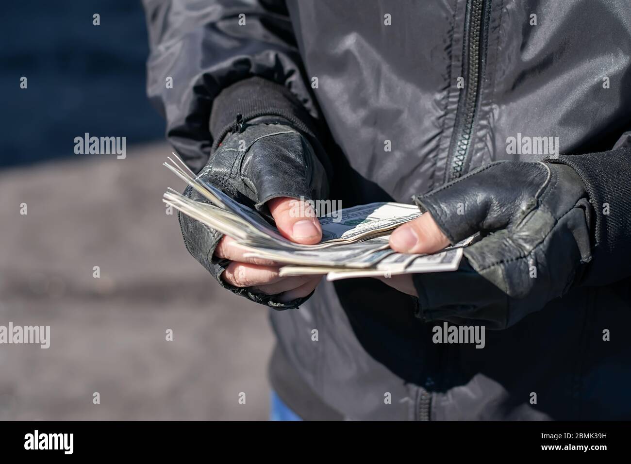 money in the hands of a bandit, a robber who counts the loot Stock ...