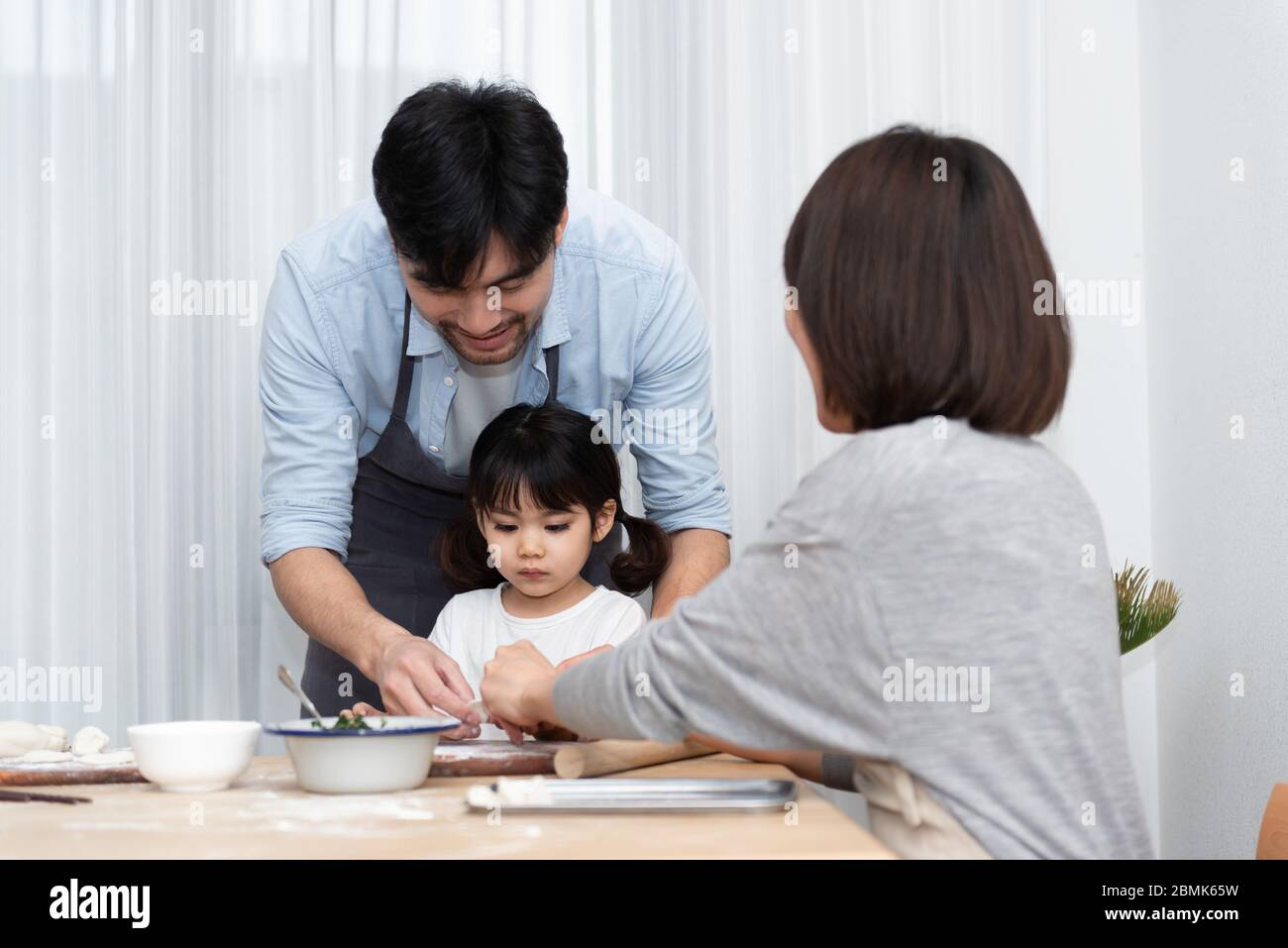 Young Asian mom and dad making dumplings with daughter Stock Photo - Alamy