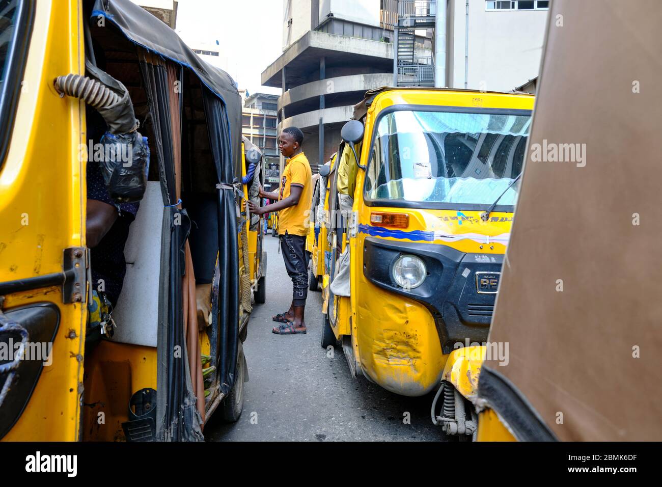 Yellow rickshaws on the streets of downtown Lagos Stock Photo - Alamy