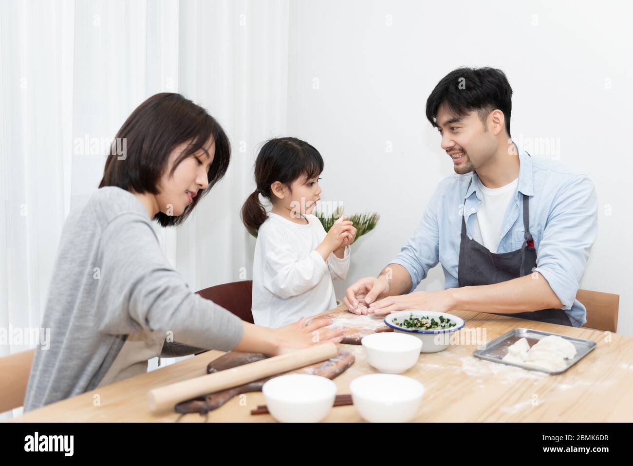 Young Asian mom and dad making dumplings with daughter Stock Photo - Alamy