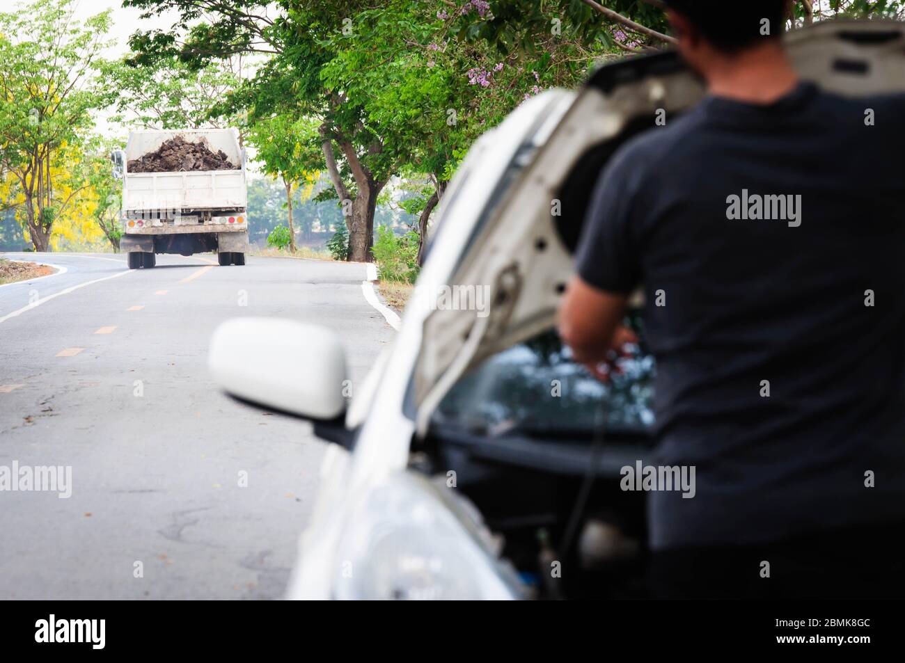 A man checking car's engine at roadside Stock Photo - Alamy