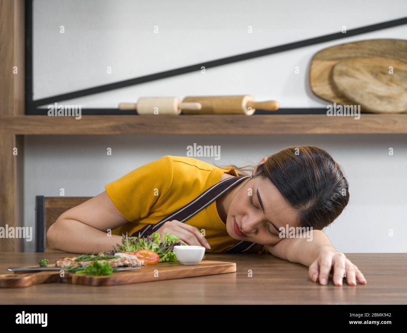Housewife fell asleep on the table where steaks and side dishes were ...
