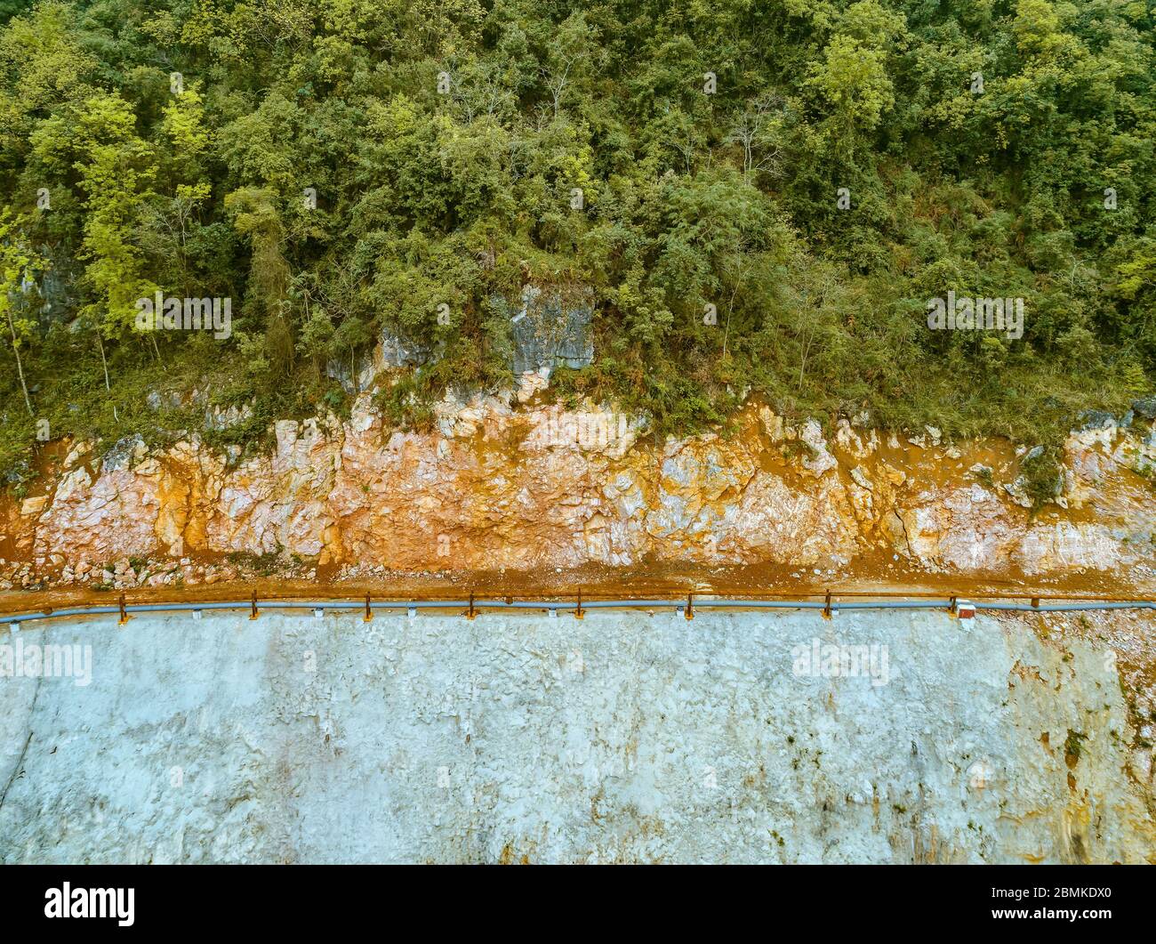Aerial View of concrete wall and rubble road beside a tailing ponds ...