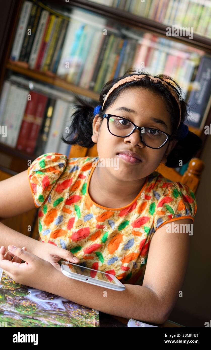 Little Indian girl studies at home maintaining social distance during ...