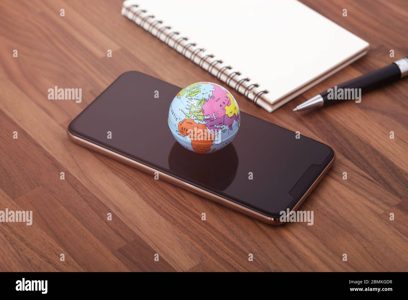 Digital business world concept. World map on smartphone on office table ...