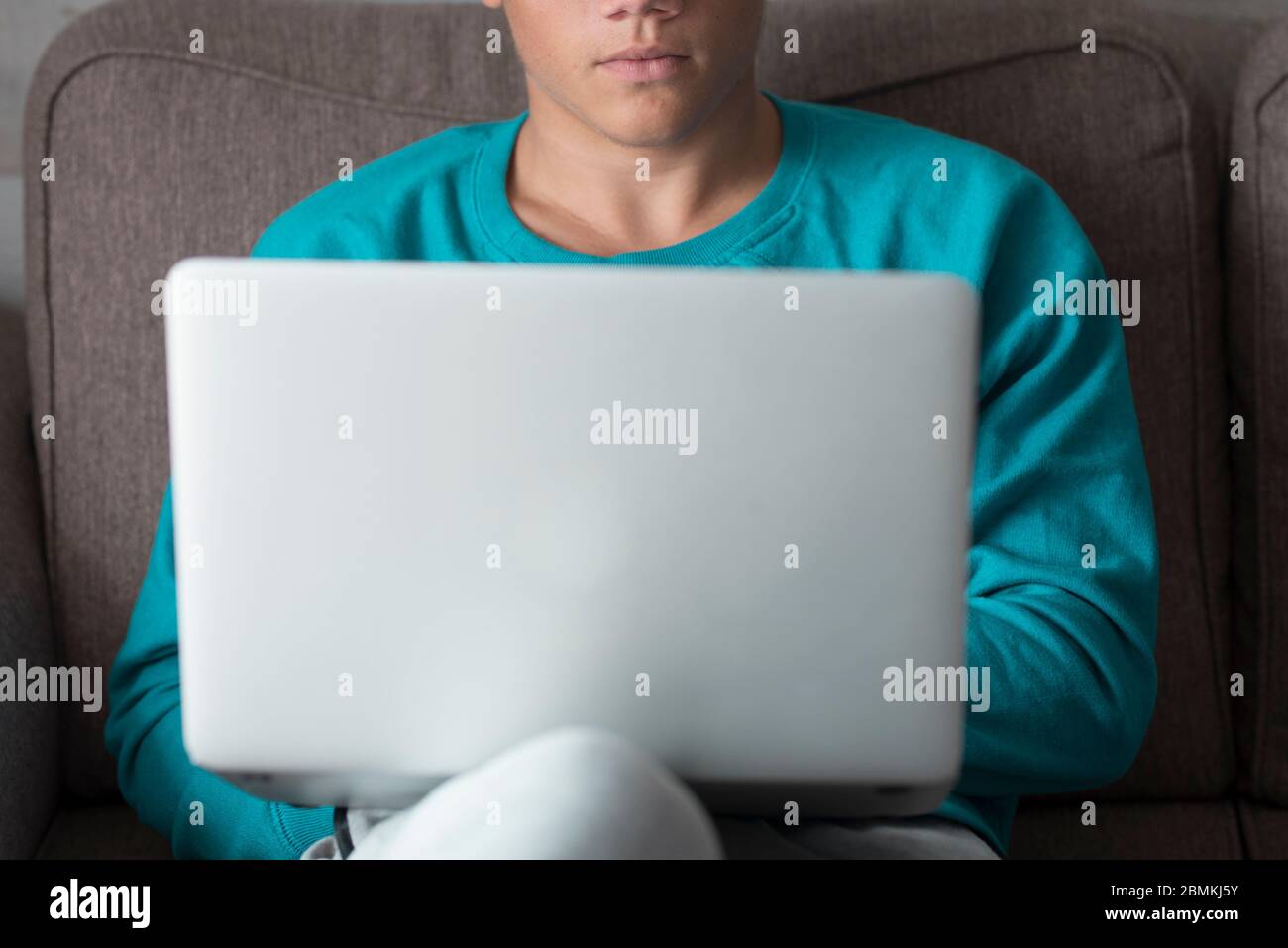 Half. face portrait of young caucasian male teenager use laptop ...