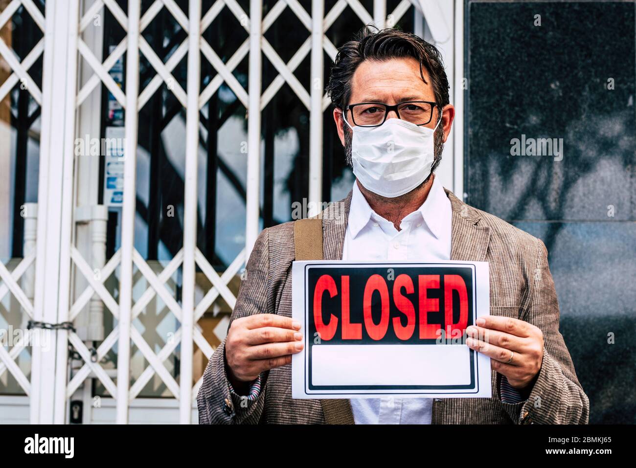 Adult professional businessman with closed sign outside his store for ...