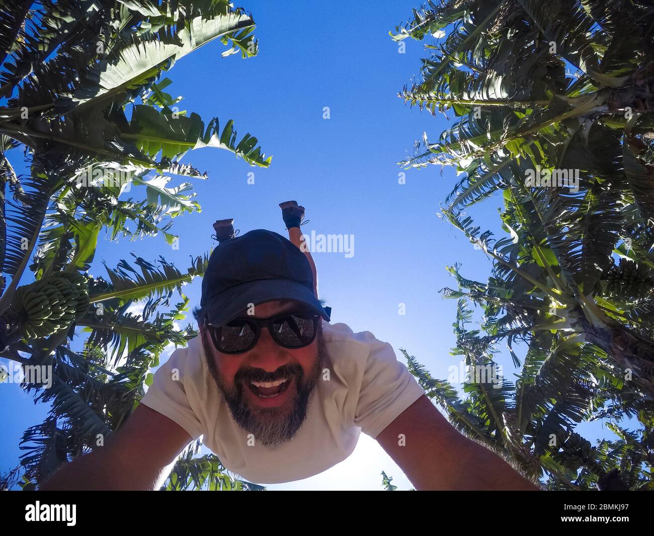 Alternative ground view of cheerful crazy man standing on his hands and ...