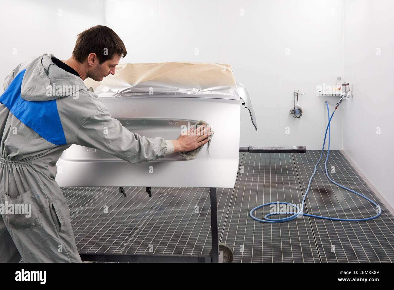 Auto mechanic preparing the car for paint job in painting booth in auto ...