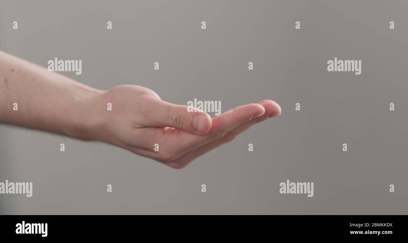 man stretches empty cupped hand on neutral background Stock Photo - Alamy