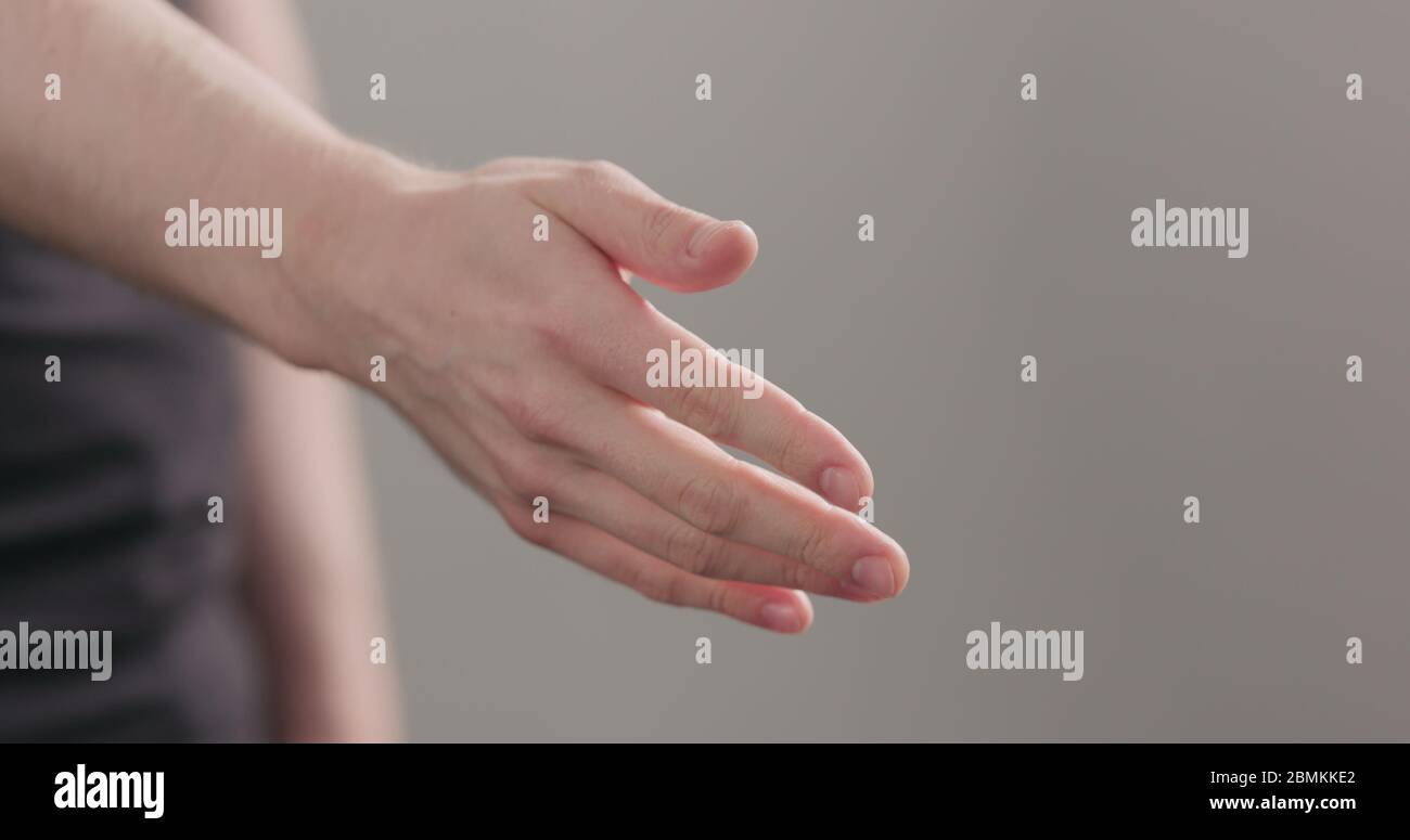 man stretches hand for a handshake or help on neutral background Stock ...