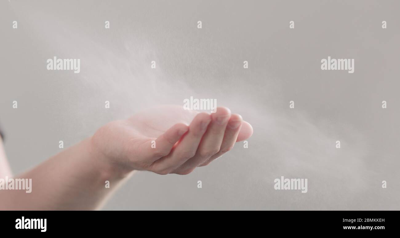 man spraying sanitizer on his hands side shot Stock Photo - Alamy