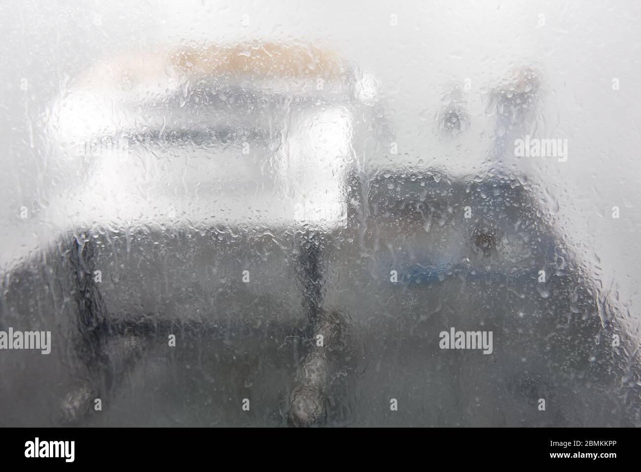 View through wet glass on Drying parts of the automobile in spray booth ...