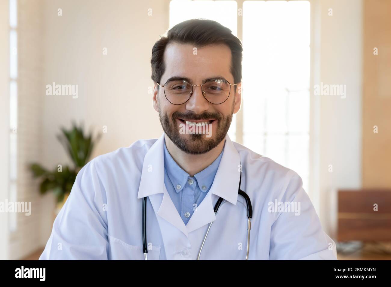Portrait of smiling male doctor posing at workplace Stock Photo - Alamy