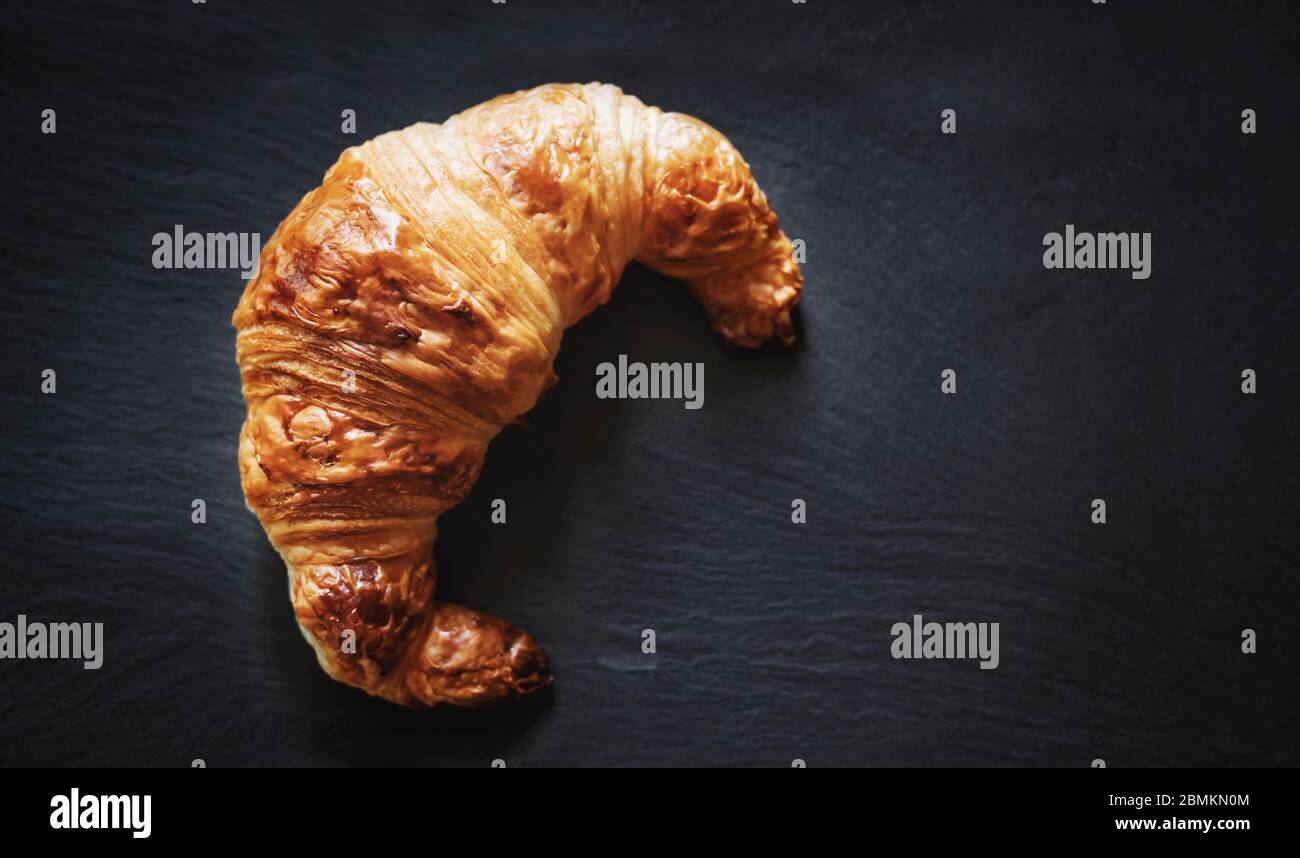 Fresh French Croissant on black stone plate texture background Stock ...