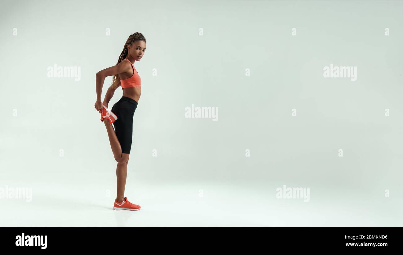 Warming up before training. Full length of young african woman with ...