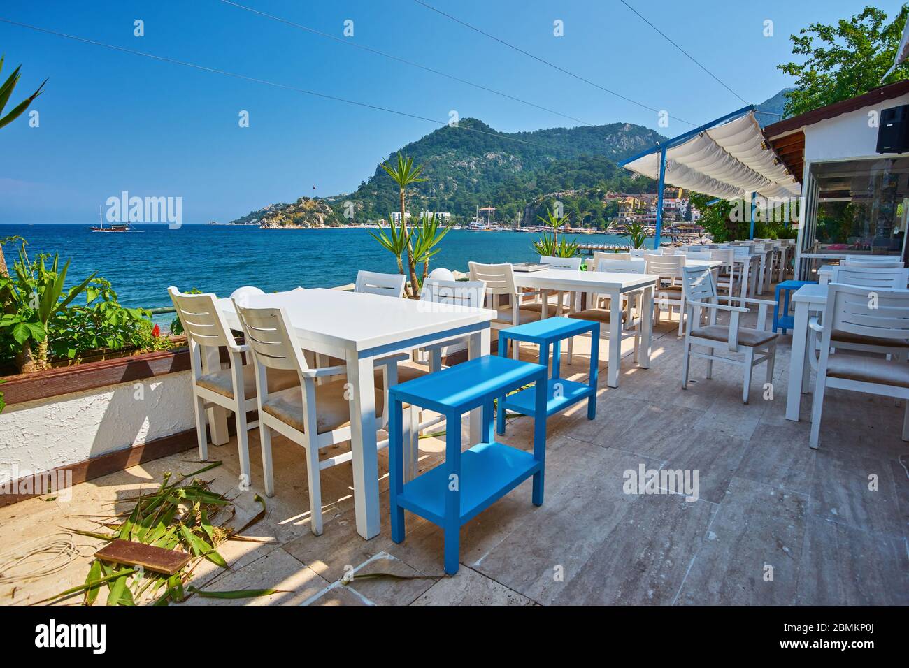 Traditional greek street cafe with flowers. Empty tables and chairs of ...