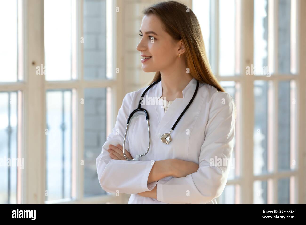 Young female doctor look in distance thinking of career opportunities ...