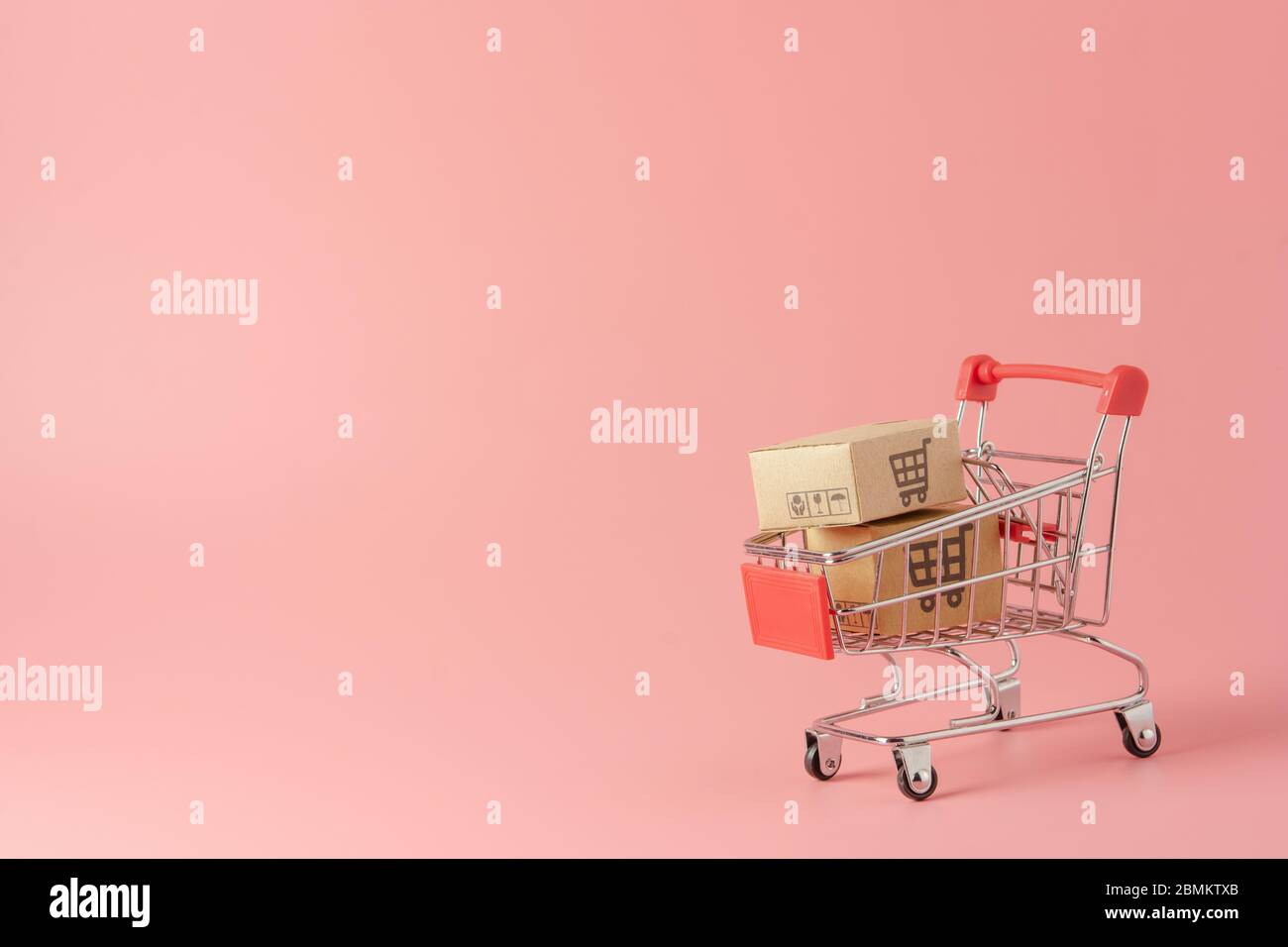 Shopping concept : Cartons or Paper boxes in red shopping cart on pink ...