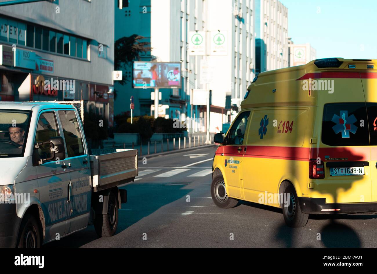 Yellow ambulance taking a left turn on an intersection, going back to ...
