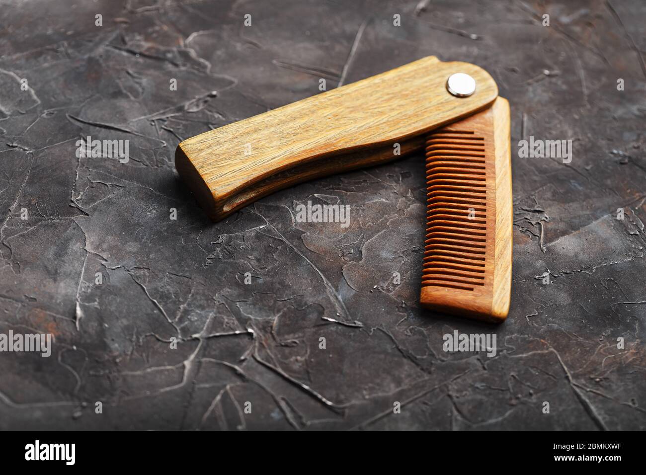 Wooden sandalwood comb on a black textured background. Hair care Stock ...