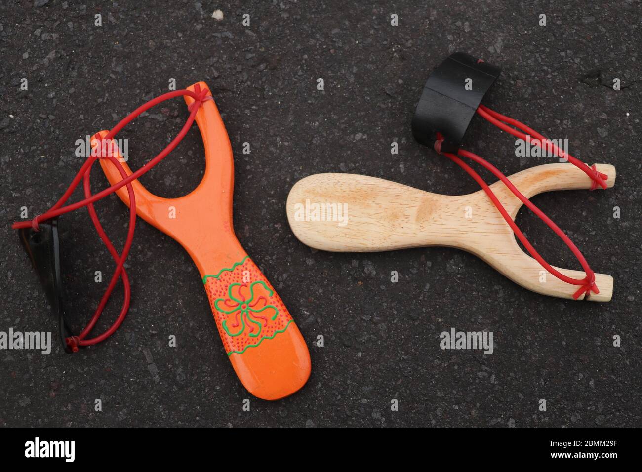 Couple of simple wooden slingshot isolated. Orange and natural wooden ...