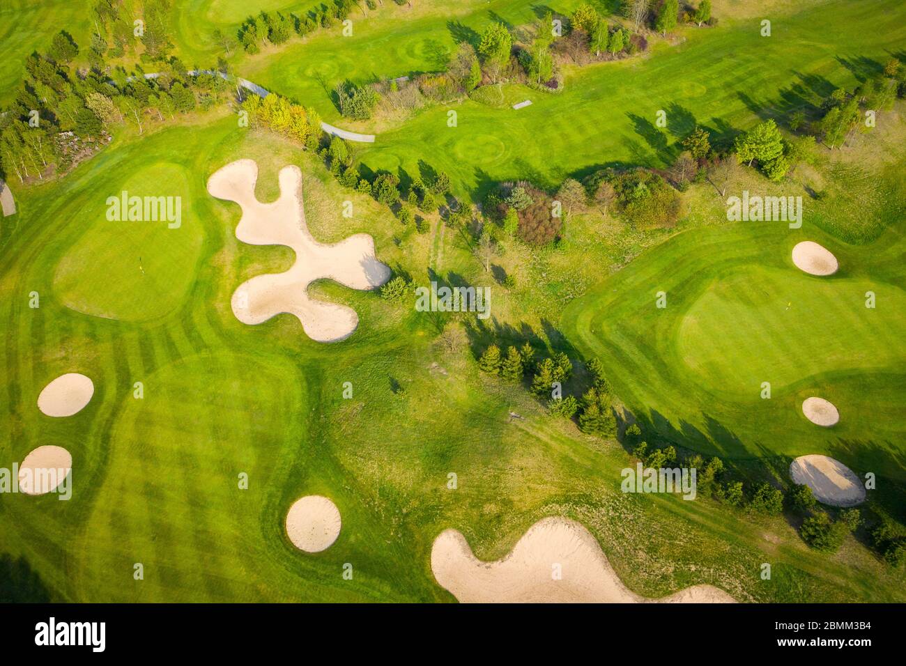 Aerial view of a golf course fairway and green with sand traps, trees ...