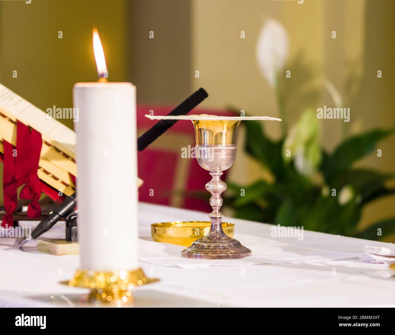in the church the lit candle illuminates the wine, blood of christ, and ...