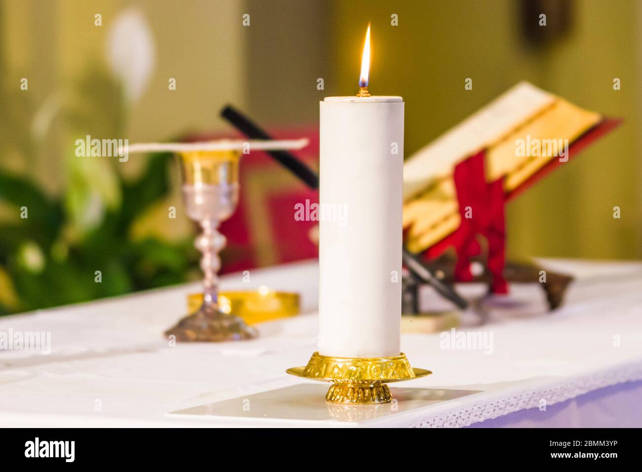 in the church the lit candle illuminates the wine, blood of christ, and ...