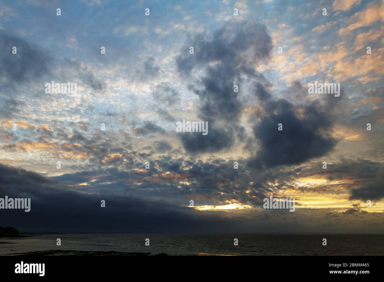 The setting sun lighting up the cloud-cover on the horizon Stock Photo ...