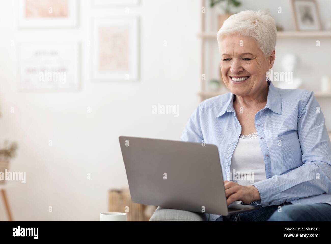 Positive Elderly Lady Using Laptop Computer At Home Stock Photo - Alamy