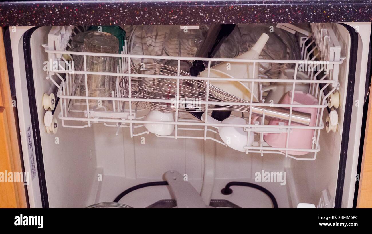 Washing dishes in the dishwasher in a residential kitchen Stock Photo ...