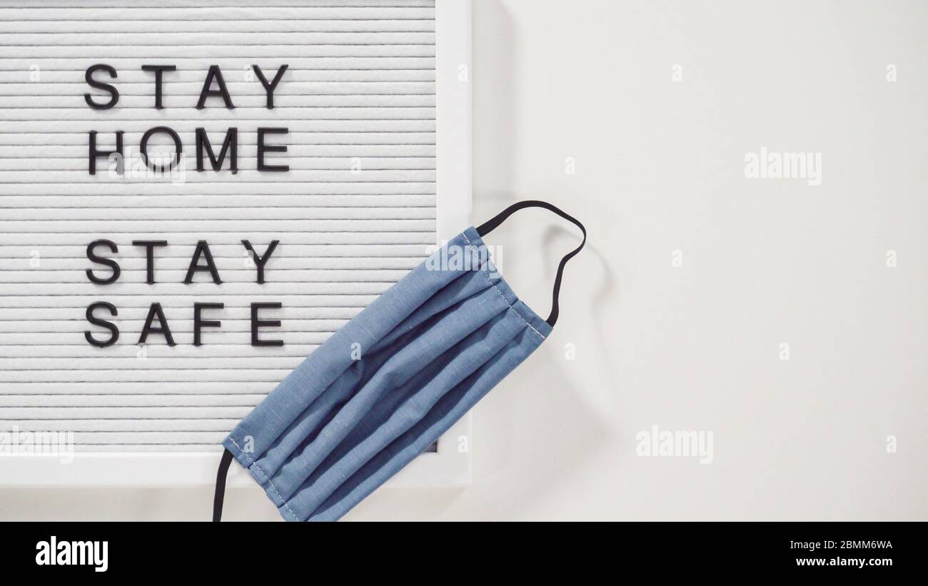 Flat lay. STAY HOME and STAY SAFE sign on message board with a homemade ...