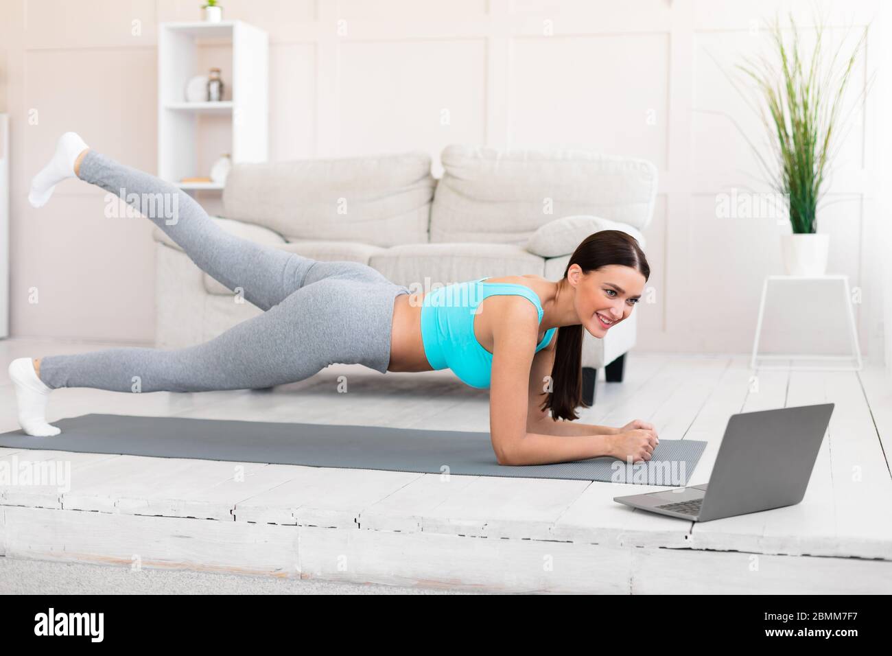 Sporty Girl Exercising At Laptop Standing In Plank At Home Stock Photo ...
